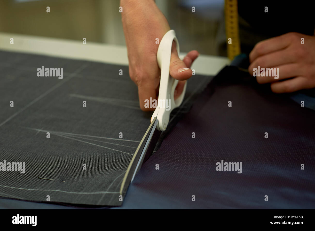 Master cuts fabric. Nesting. Suiting fabric marked with white chalk ...