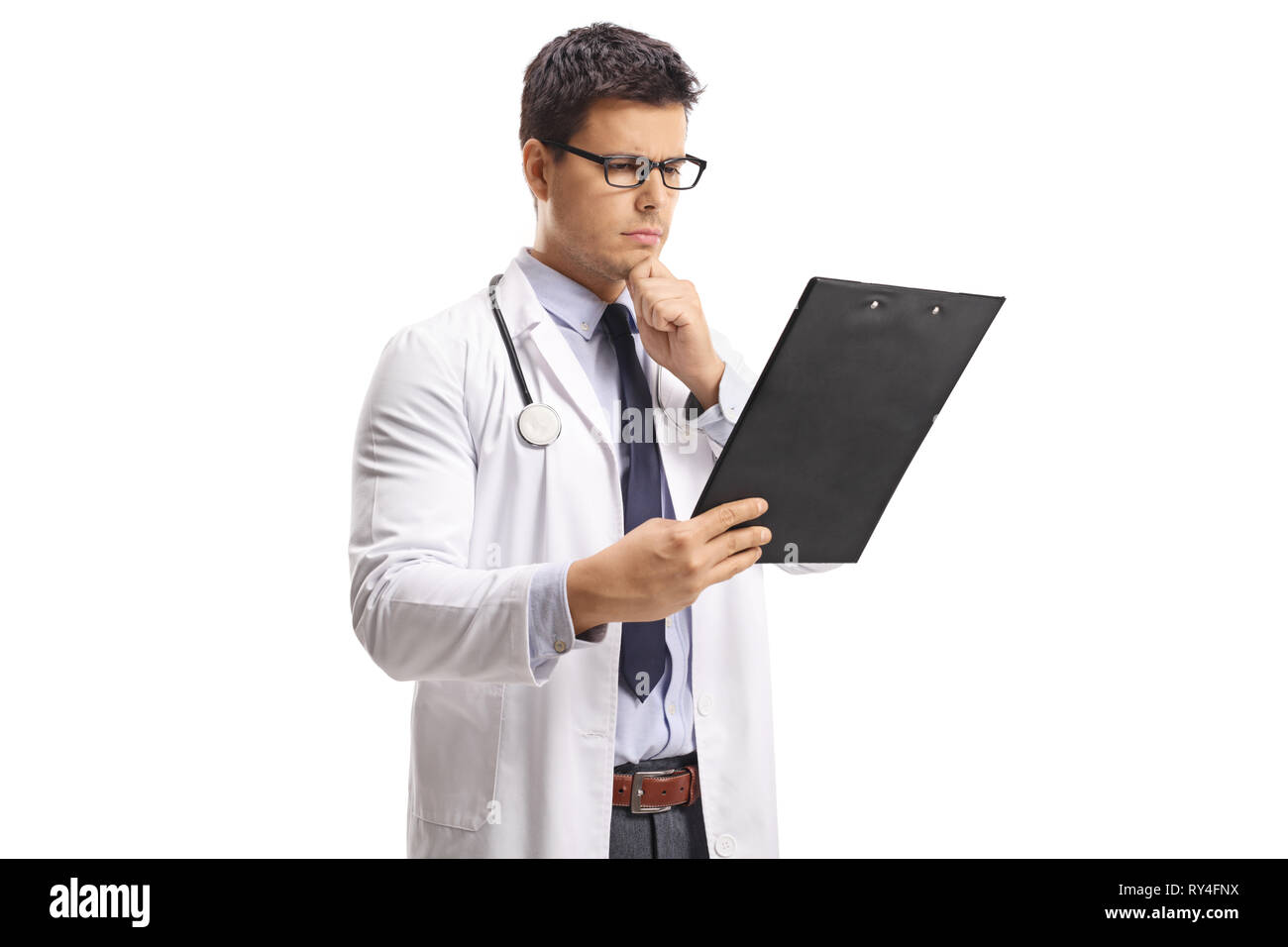 Young male doctor looking at a paper on a clipboard and thinking ...