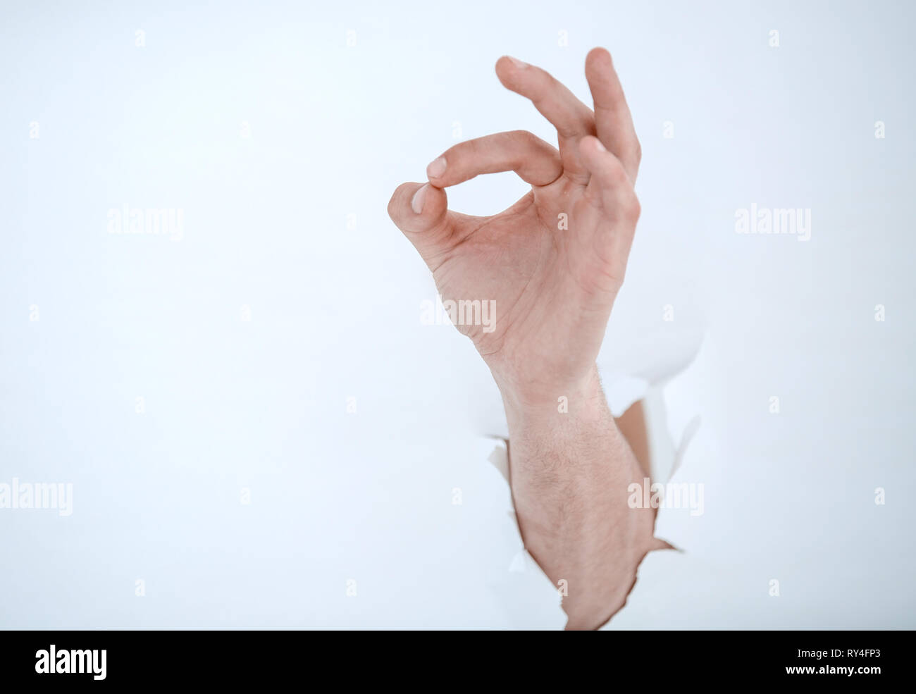 hand breaks through the paper with a gesture OK Stock Photo - Alamy
