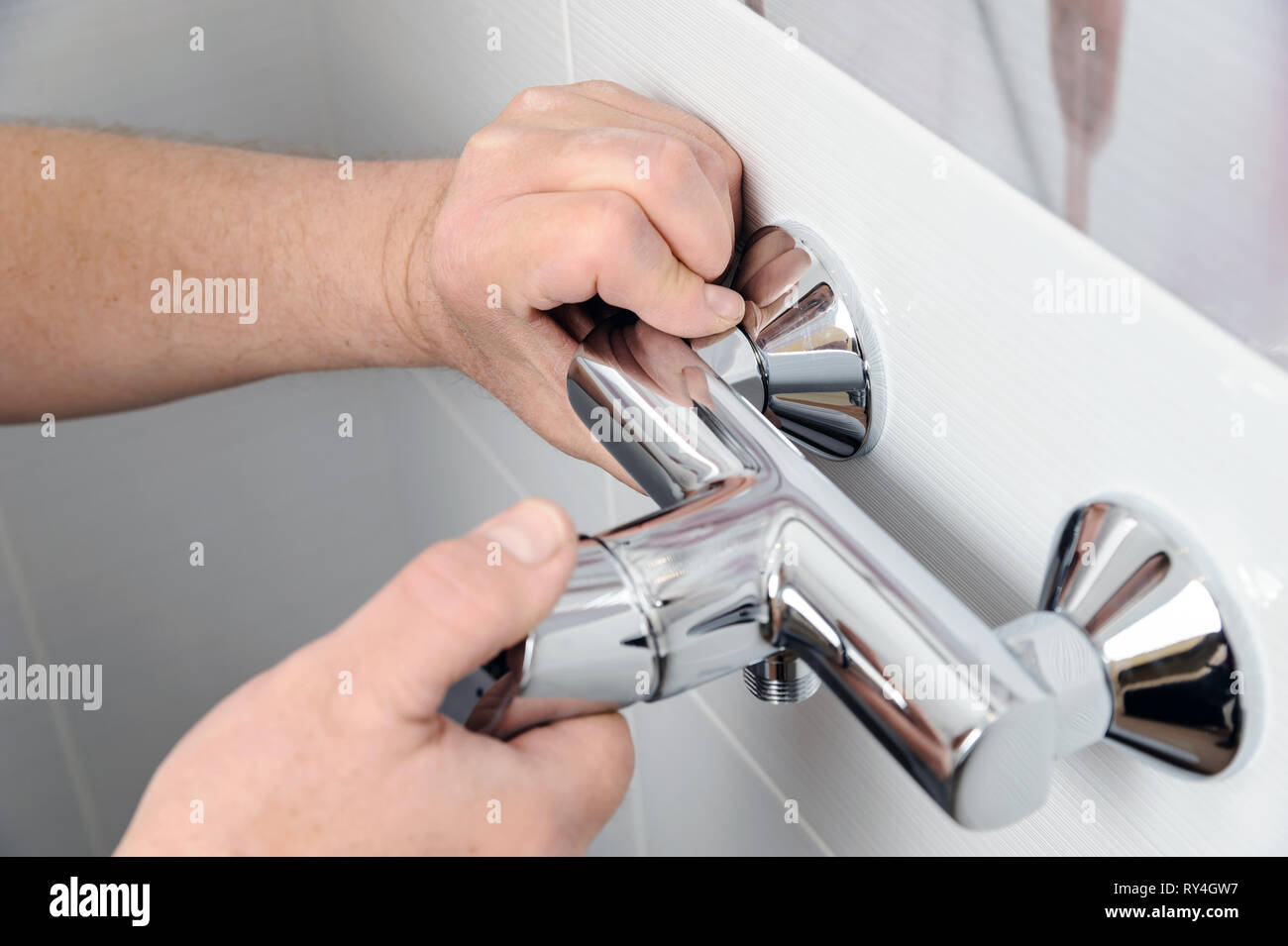 Man's hands fixing a shower faucet to the place Stock Photo - Alamy