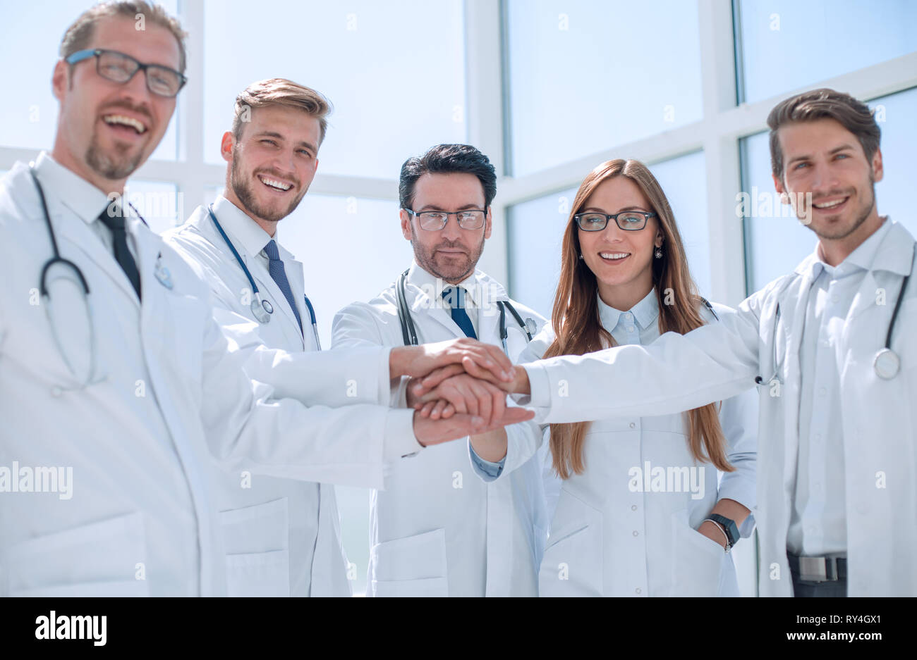 group of doctors with their hands folded together Stock Photo - Alamy
