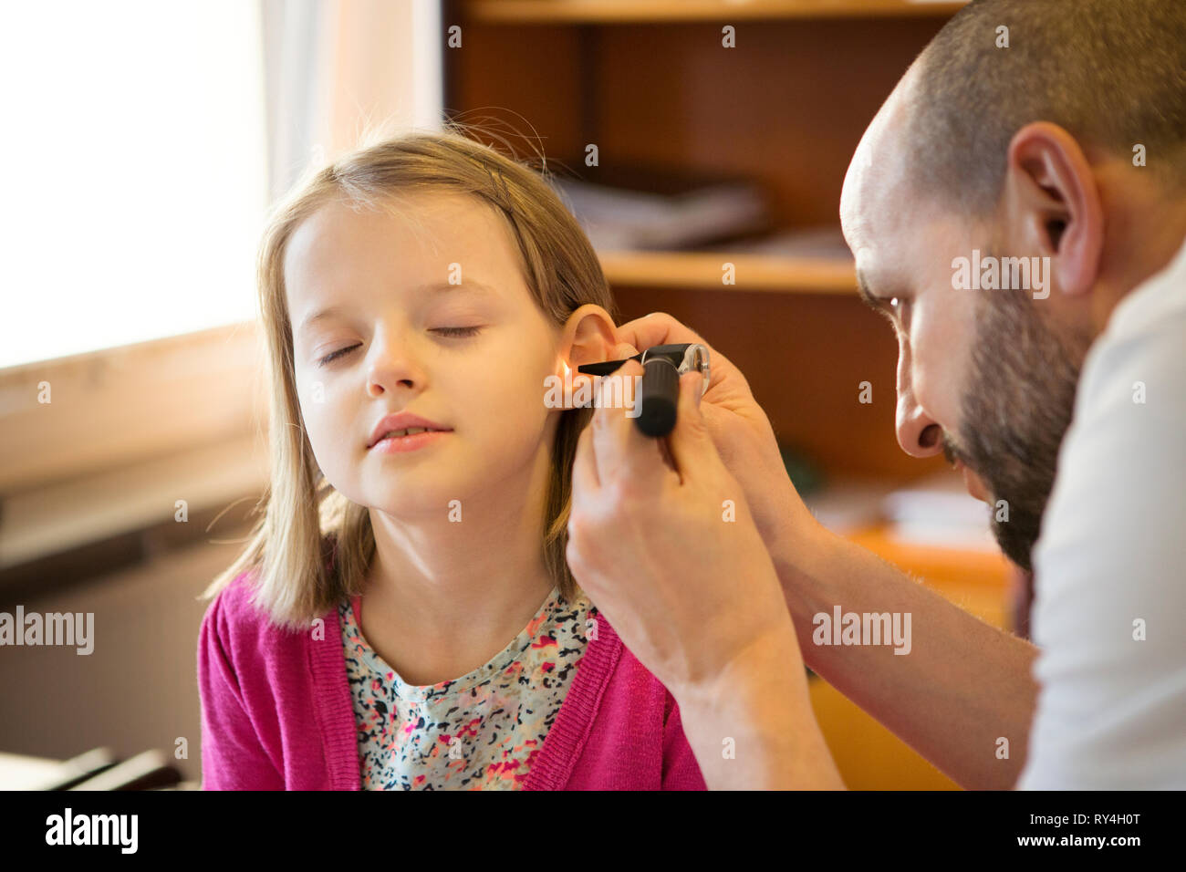 Doctor examining child's ear with auriscope Stock Photo - Alamy