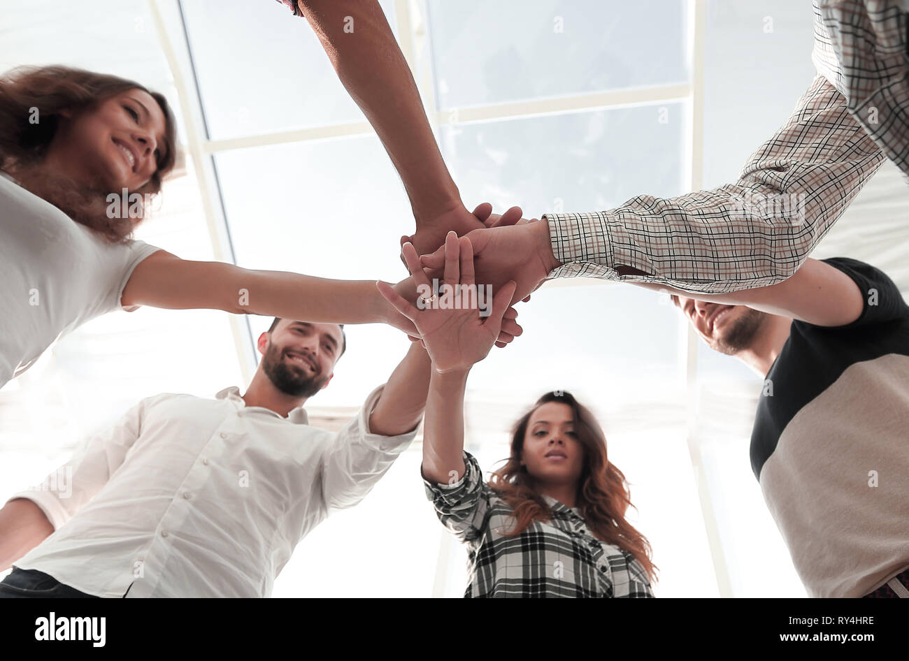 young people with hands clasped together Stock Photo - Alamy