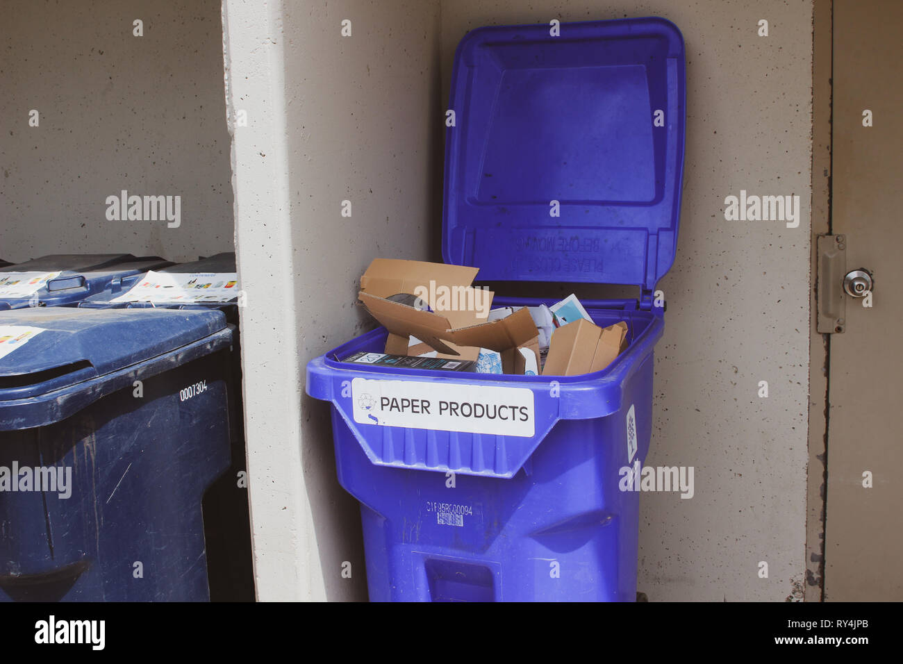 garbage bins are overfilled with packages with waste on the road ...