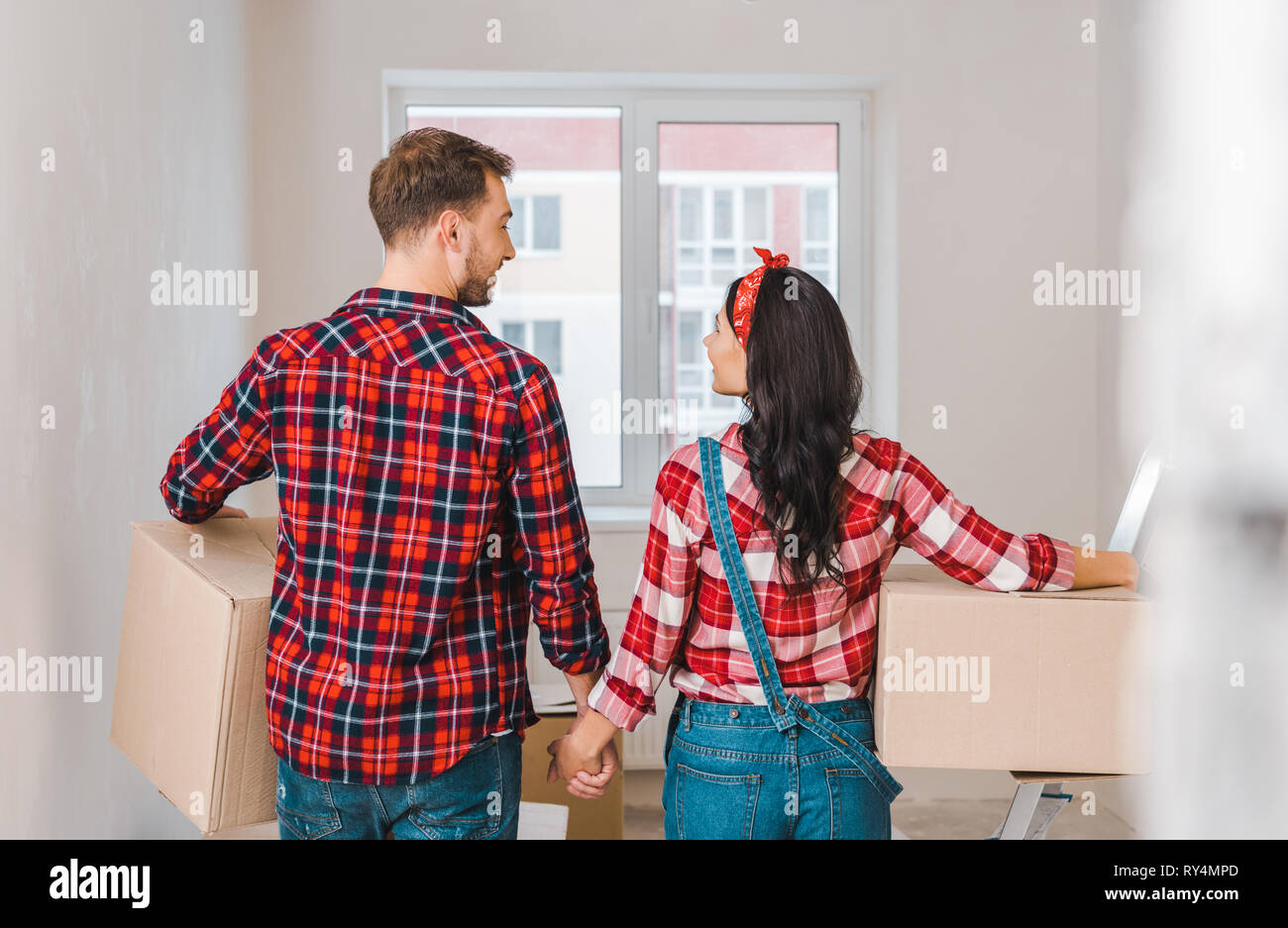 boyfriend and girlfriend with boxes holding hands at home Stock Photo ...