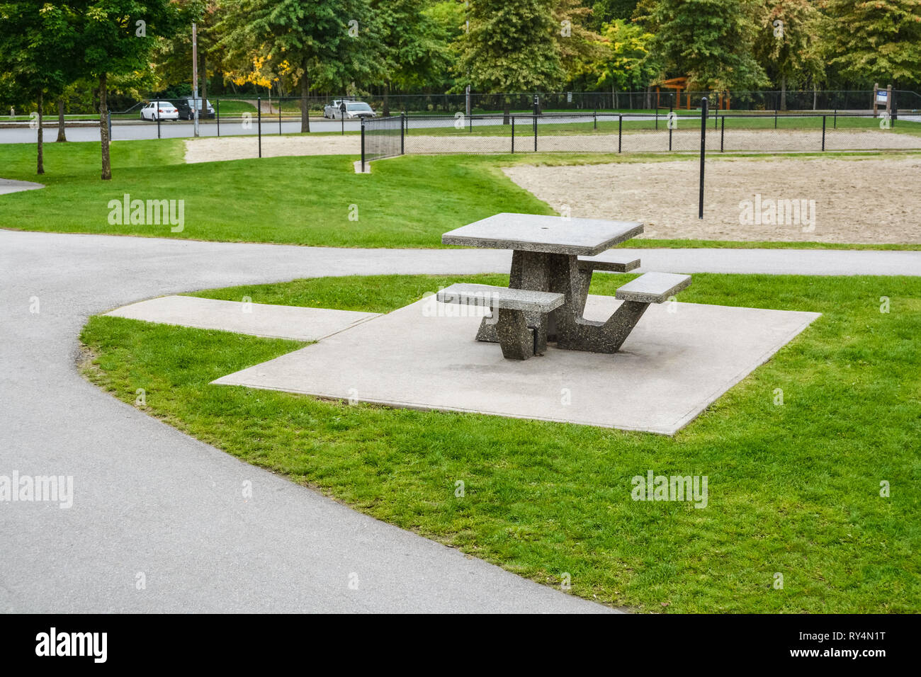 Picnic table and benches on green lawn in a park. Urban recreation area ...