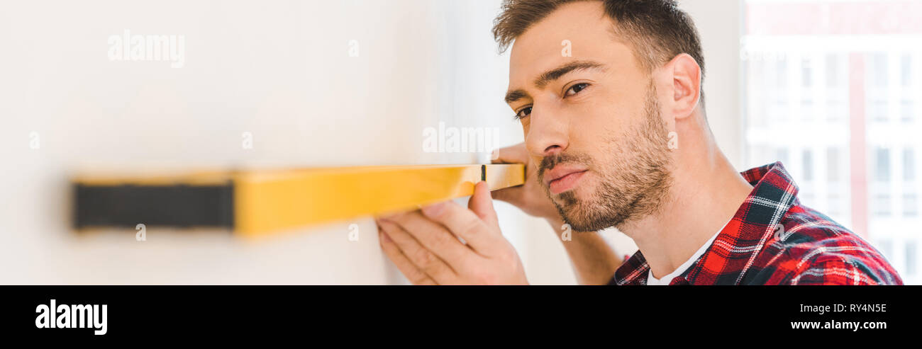 serious man measuring wall at home Stock Photo - Alamy
