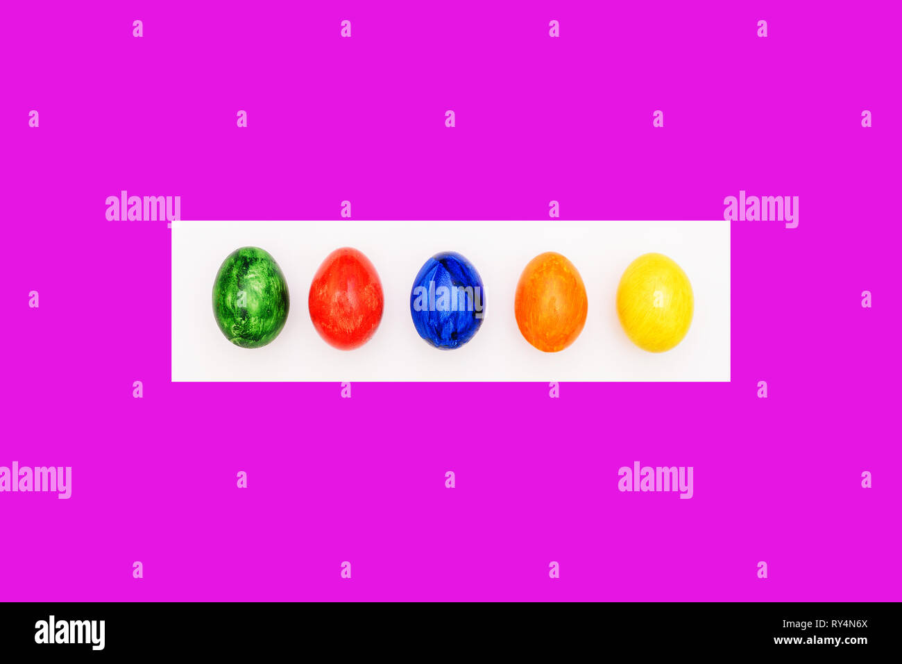 Multi-colored eggs on a purple and white background. Painted eggs ...
