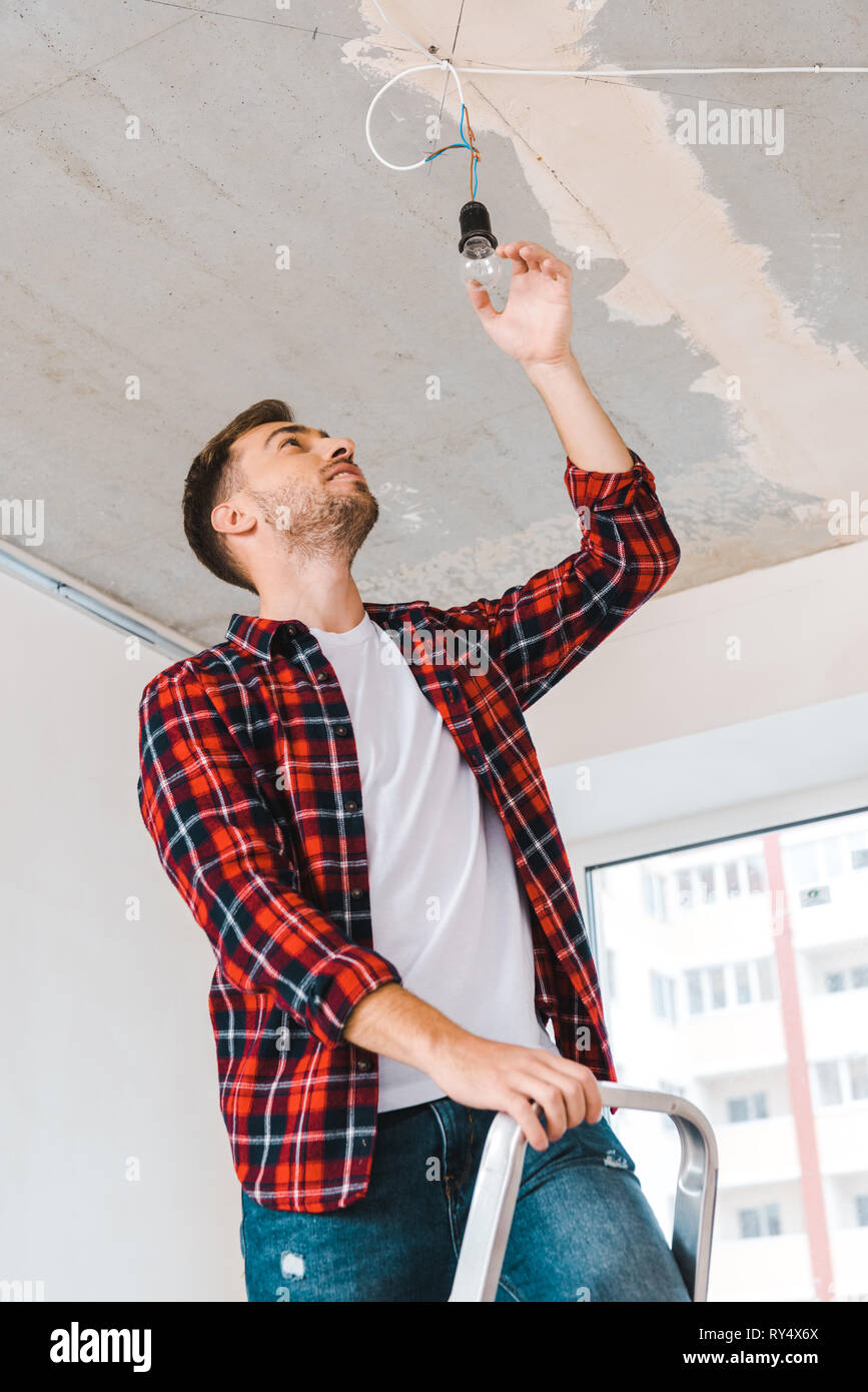 Man changing light bulb on ladder hi-res stock photography and images ...