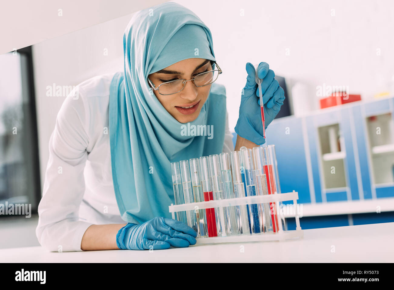 female muslim scientist adding blood in test tube in laboratory Stock ...