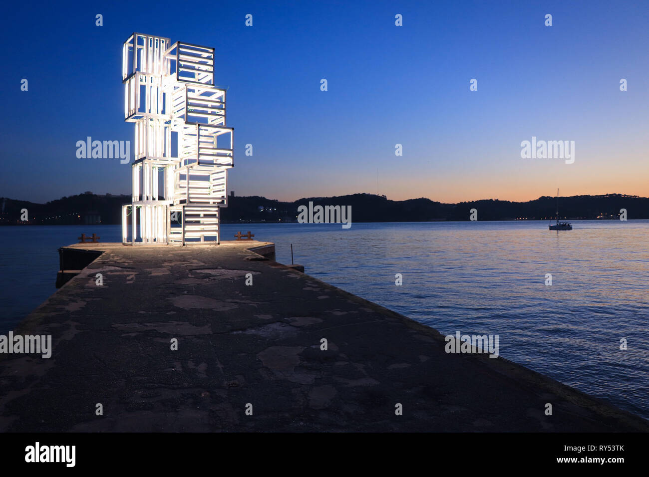 Jetty with a illuminated structure at the sunset Stock Photo - Alamy