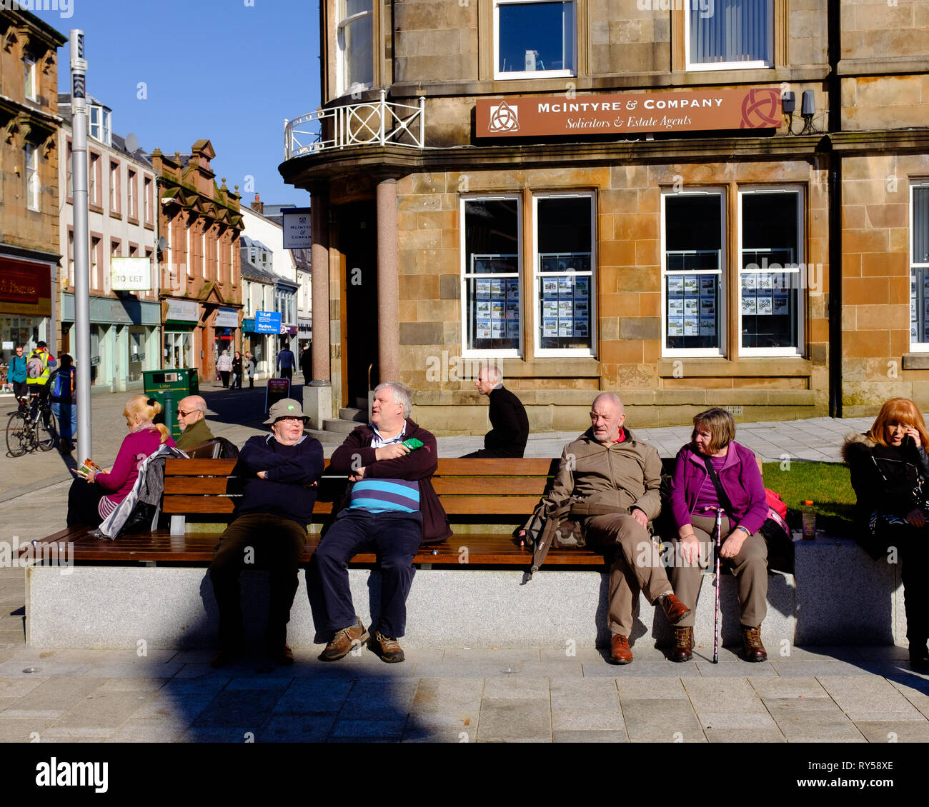 Couples sitting in cameron square fort william on public benches ...