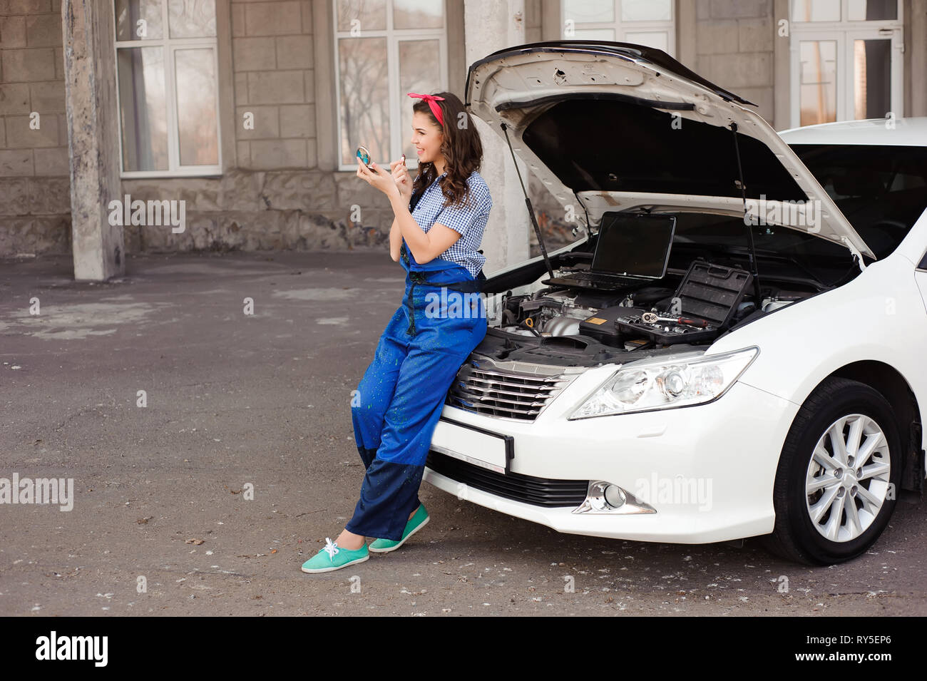 Cute attractive girl examining car engine at the auto repair shop Stock ...