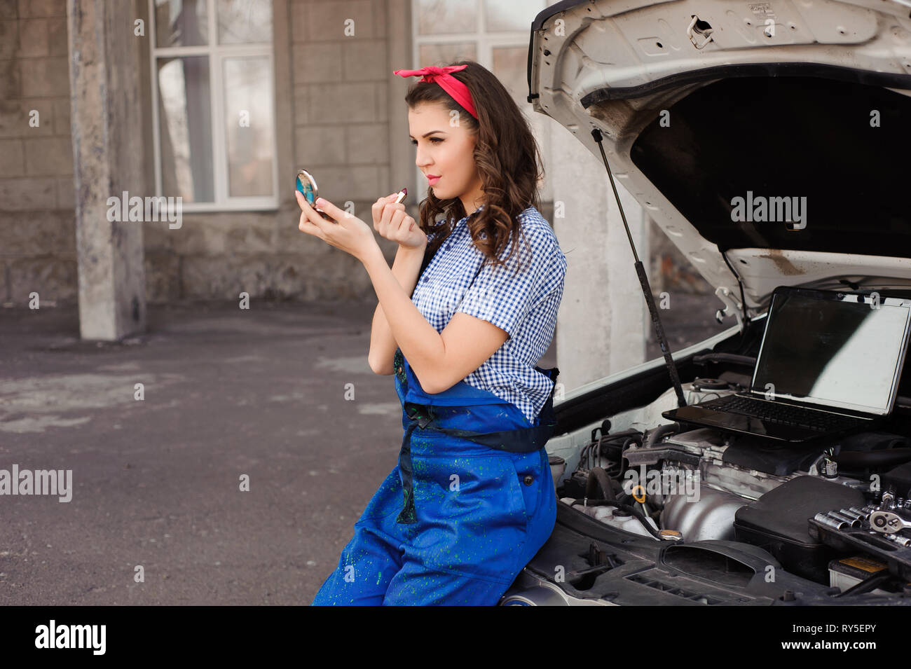 Cute attractive girl examining car engine at the auto repair shop Stock ...