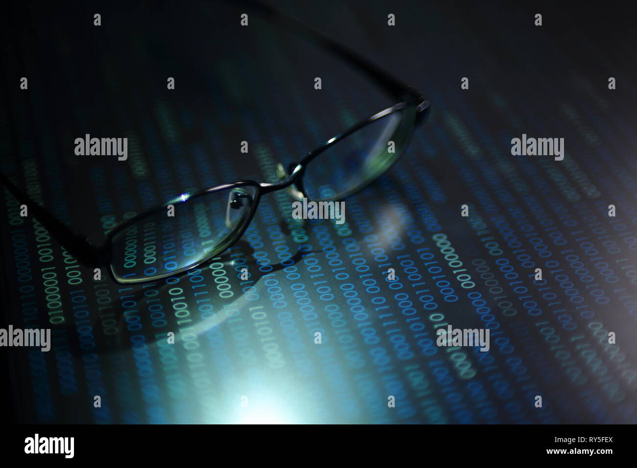 reading data in digital age. glasses and flowing binary code matrix. shallow depth of field ...