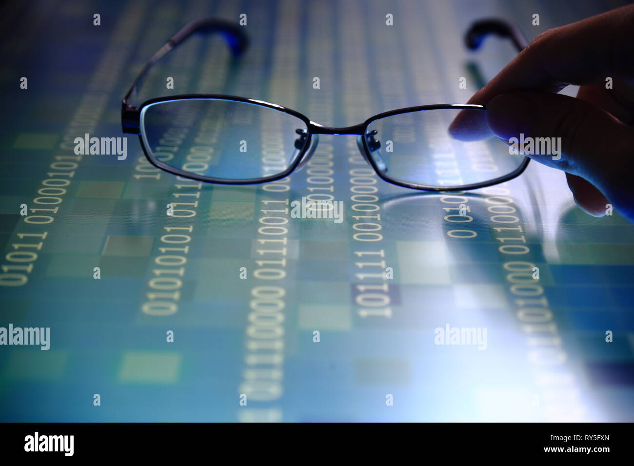 hand reaching for glasses on digital led displaying multiple layers of ...