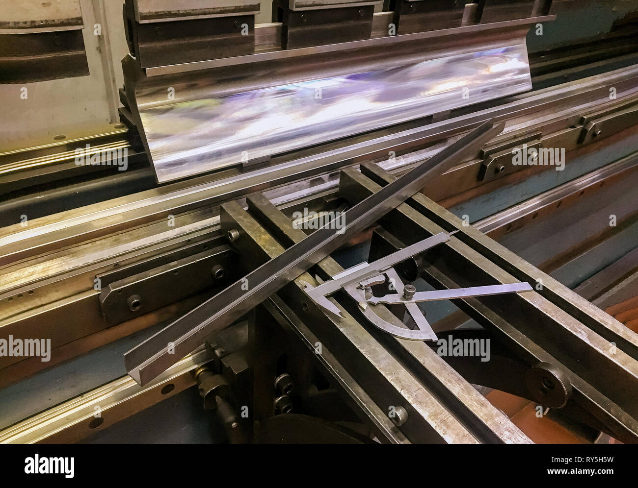 Factory at metal skip machine putting work piece in with sheet metal ...