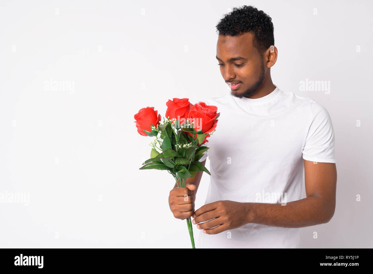 Young handsome African man holding roses ready for Valentine's day ...