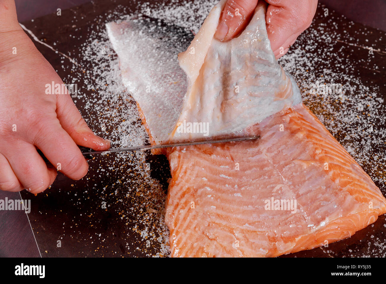 Chefs hand cut fresh piece of salmon Stock Photo - Alamy