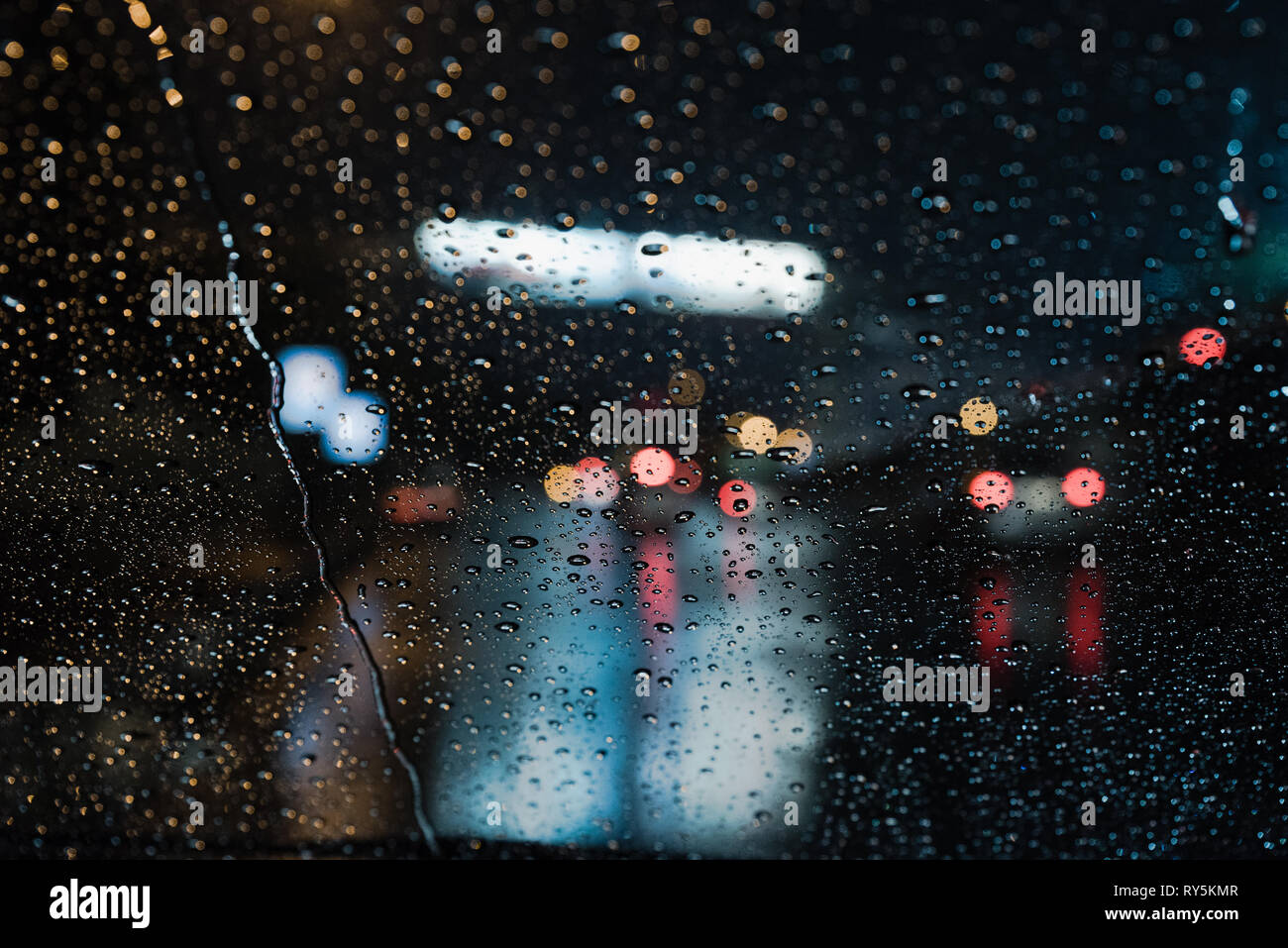 Real life rain drops from car windshield with traffic lights background ...
