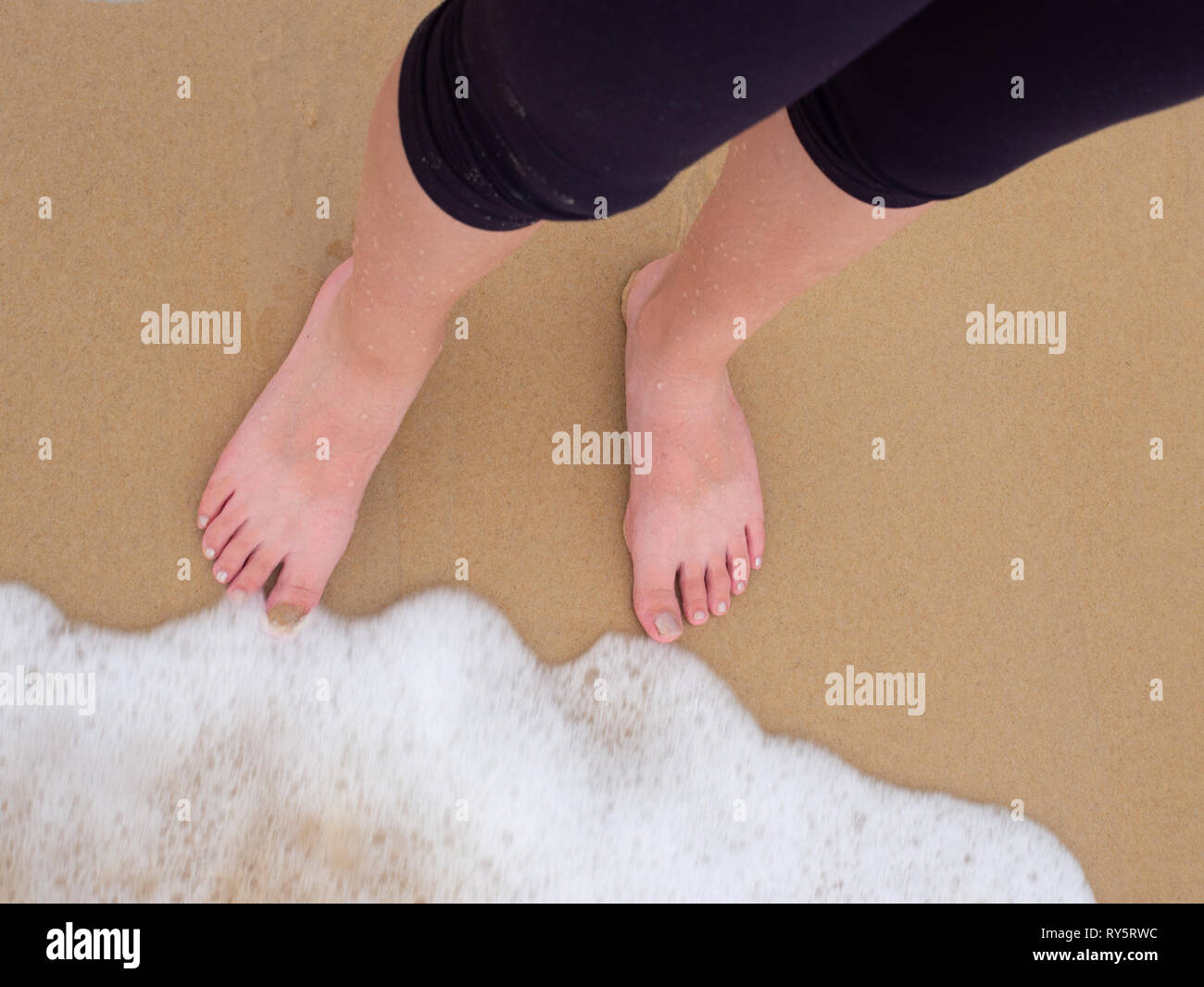 Standing On Sand At The Waters Edge Stock Photo - Alamy