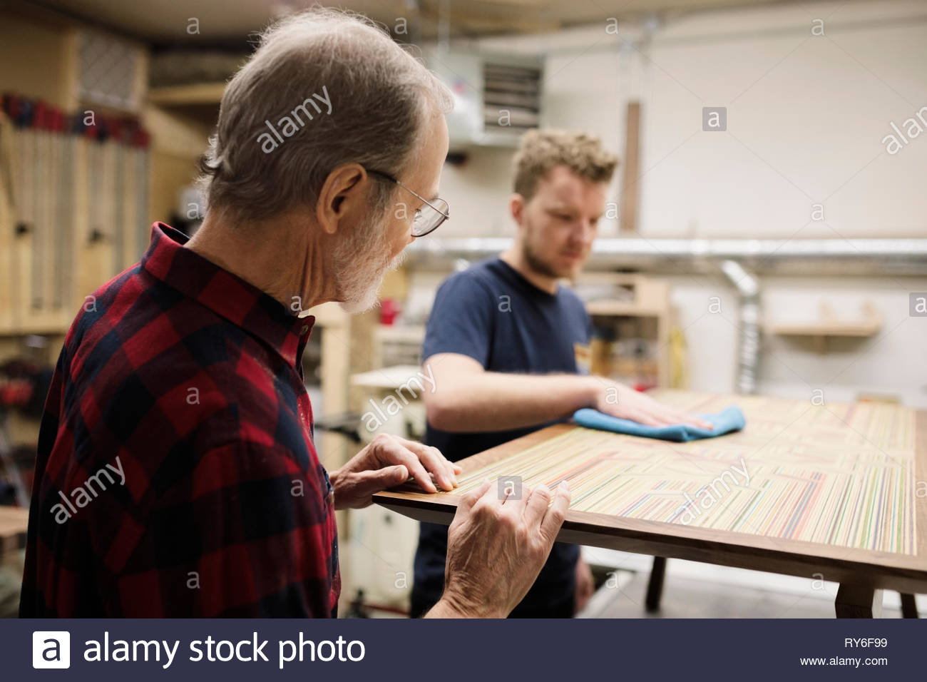 Father and son carpenters finishing table in workshop Stock Photo - Alamy