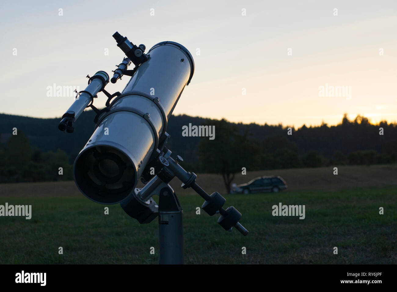 Astronomy telescope on grassy field against sky during sunset Stock ...