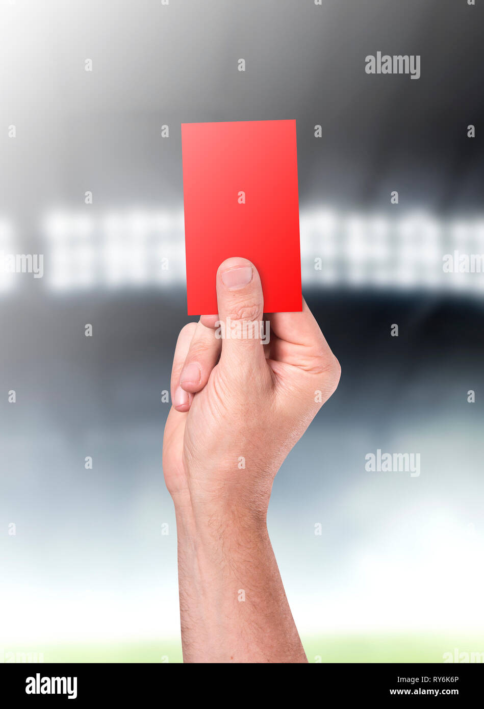 A male sports referee or umpire hand holding a red card up in the air ...