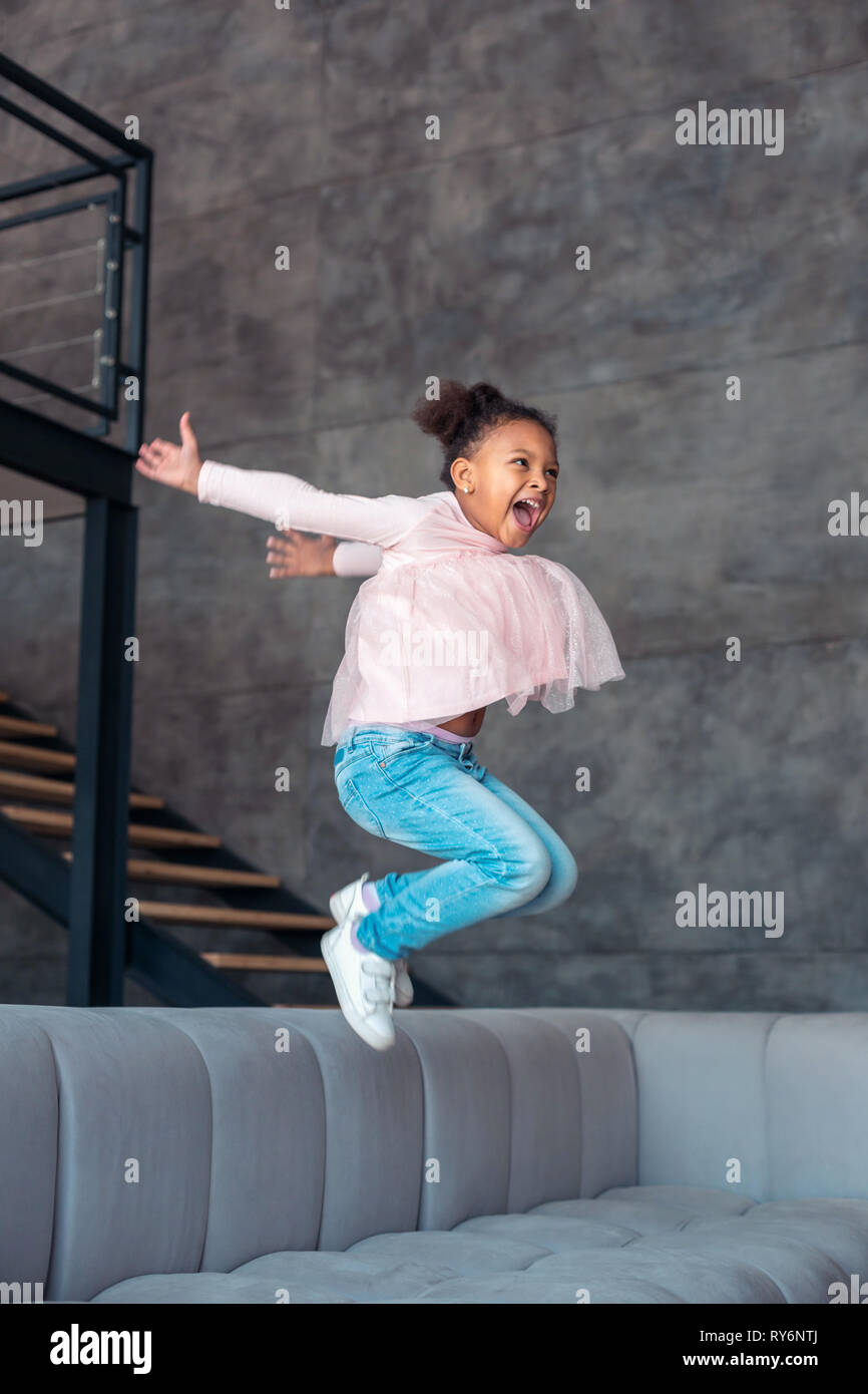 Daughter going crazy staying home alone and jumping Stock Photo - Alamy
