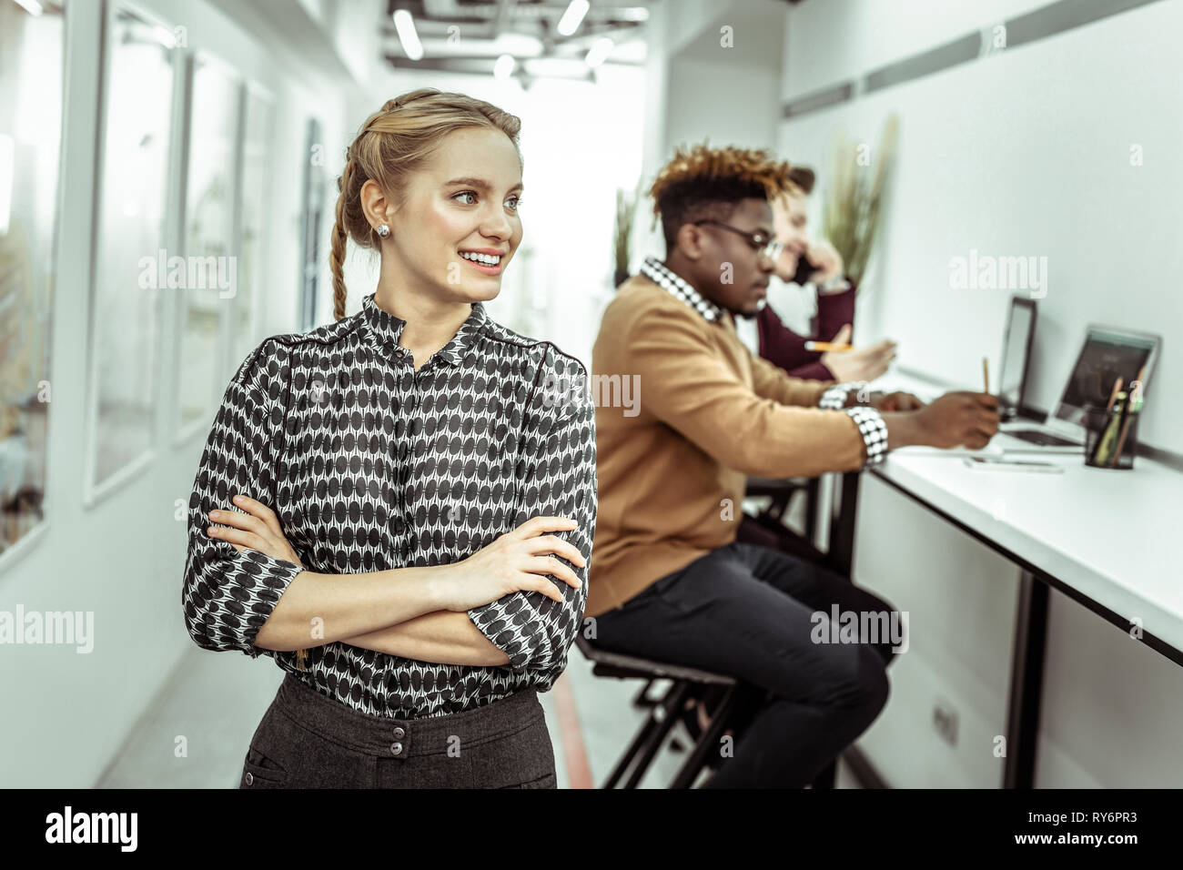 Resolute young lady in black and white shirt crossing her hands Stock ...