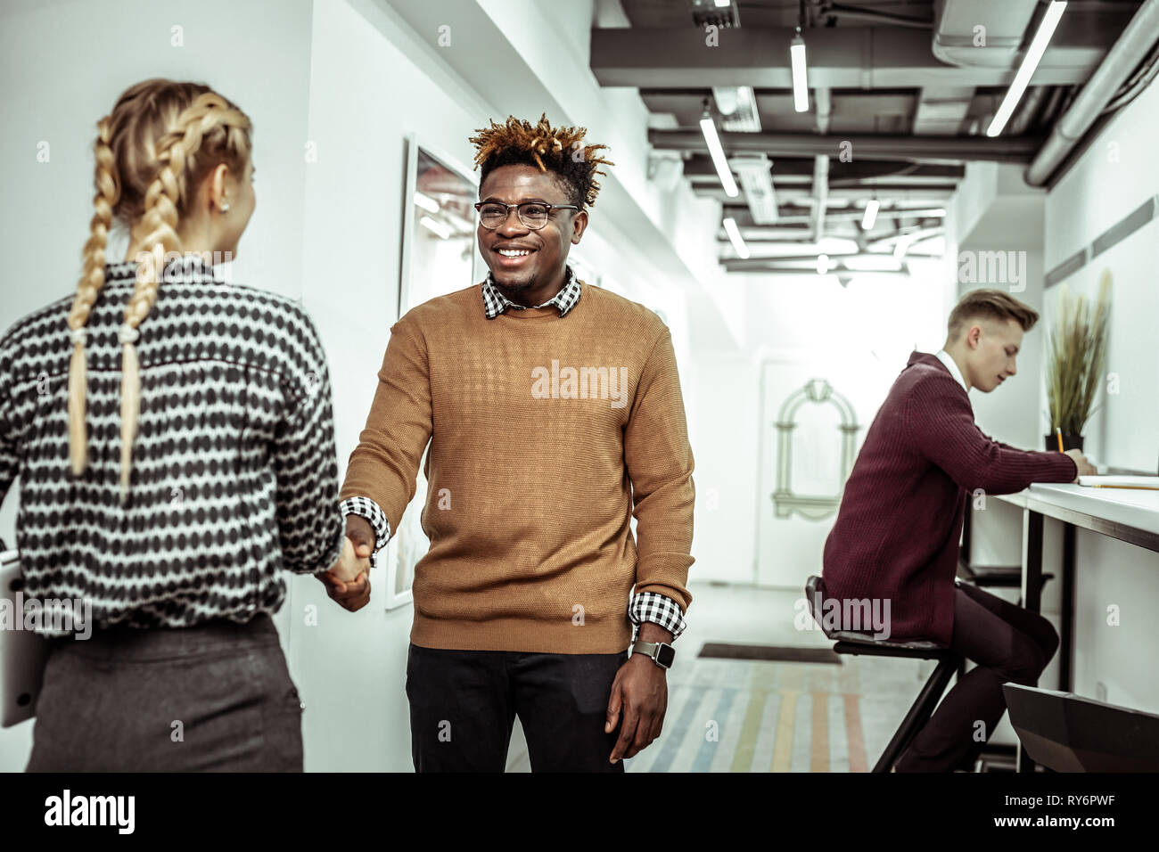 Joyful good-looking guy meeting young intern in office Stock Photo - Alamy