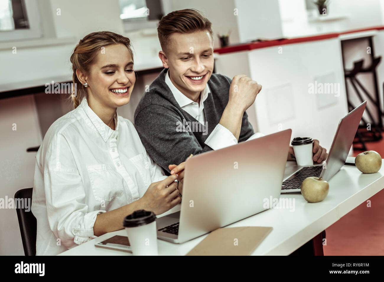 Positive young workers spending time in office while dealing with ...