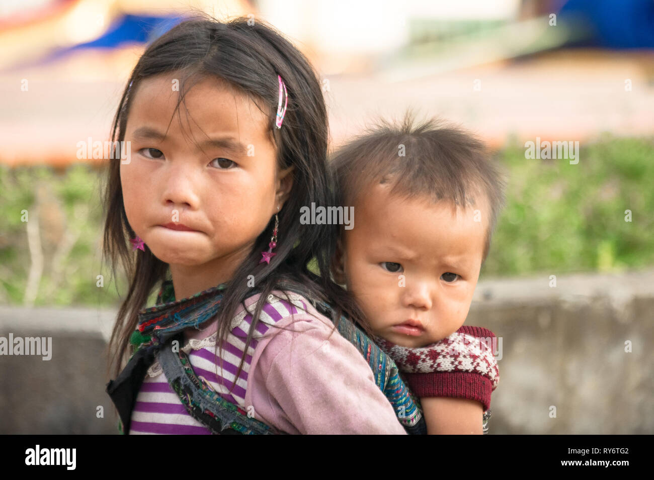 Young Hmong Girl Carrying baby Sister in Sapa, Vietnam Stock Photo - Alamy