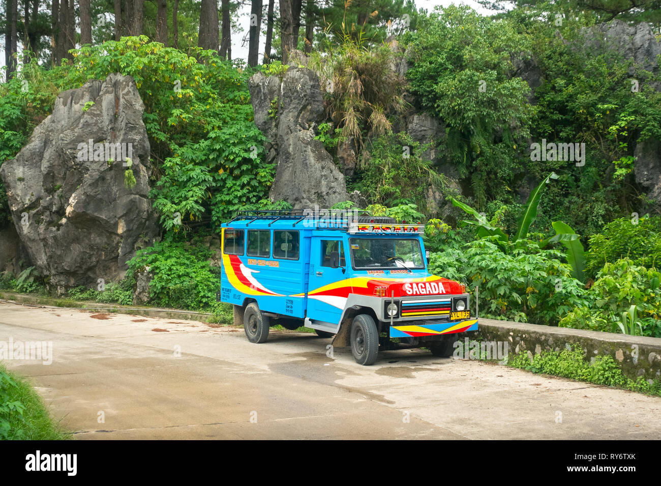 Colorful Jeepney passenger bus parked along rocky forest - Sagada ...