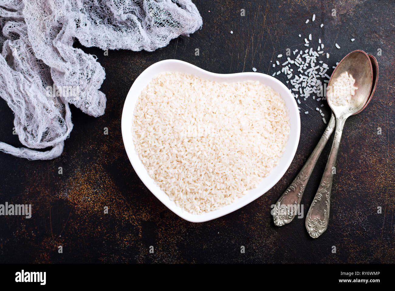 raw rice in bowl plate, rice in heart-shaped bowl Stock Photo - Alamy