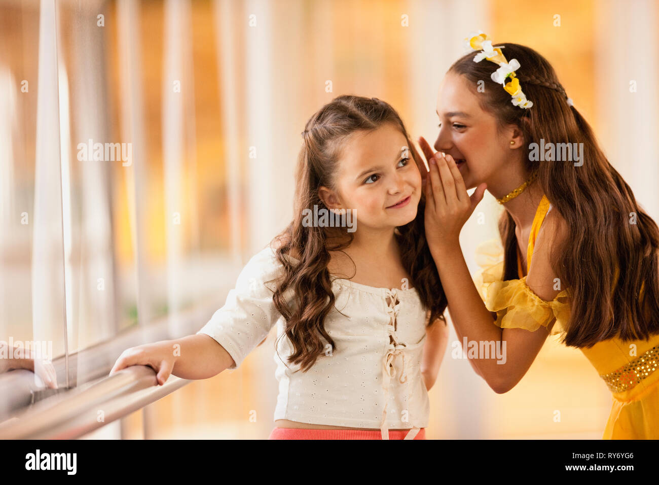 Girl whispering into teenage girls ear hi-res stock photography and ...