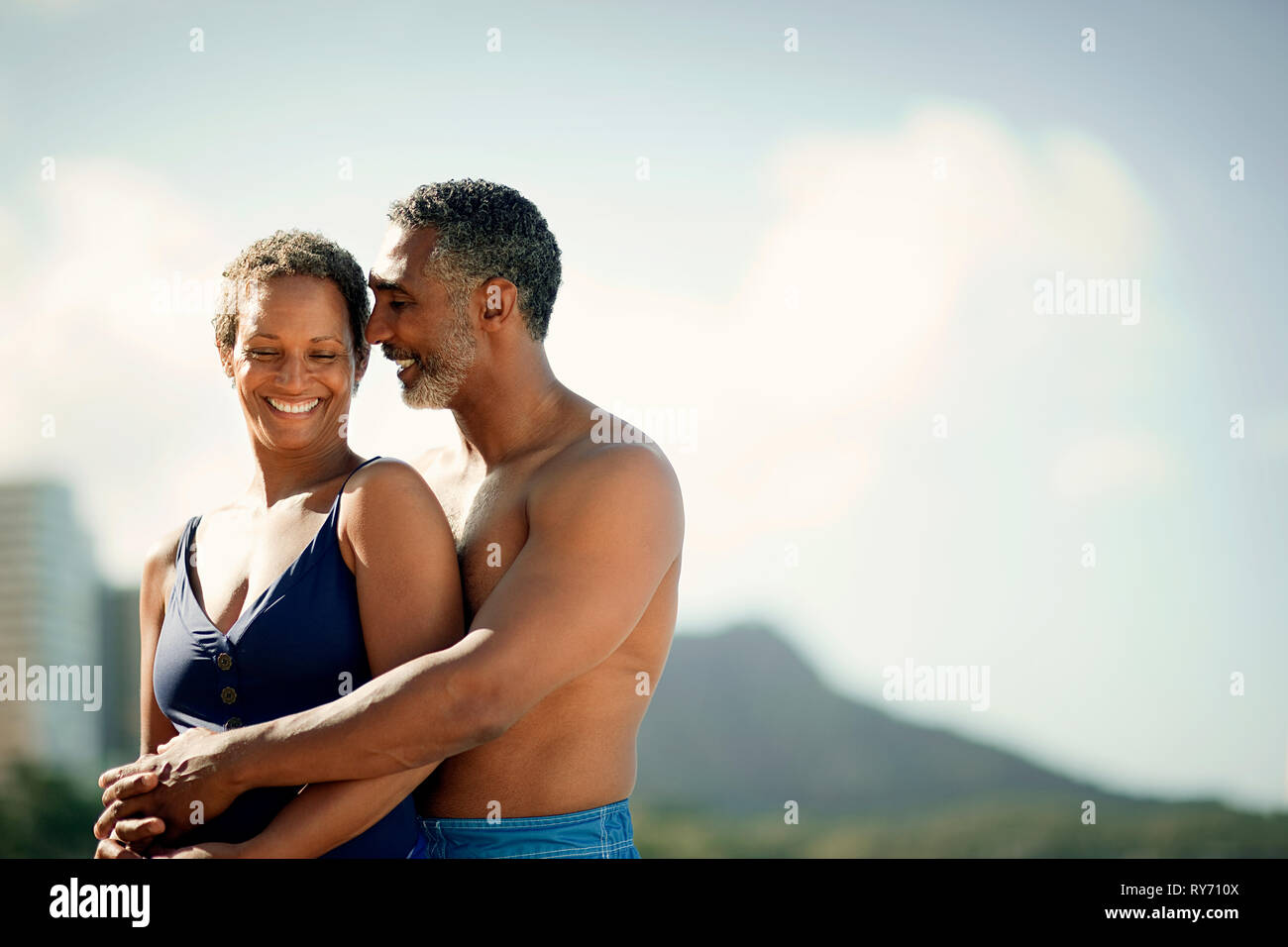 Couple hugging at beach, wearing swimwear Stock Photo - Alamy