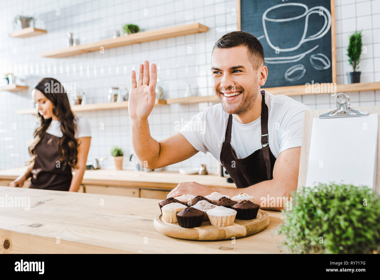 selective focus of handsome cashier standing behind bar counter and ...