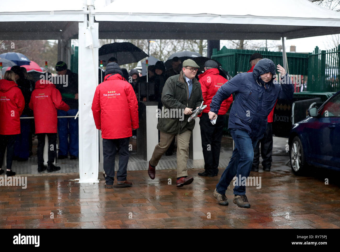 Racegoers arrive in the rain during Champion Day of the 2019 Cheltenham ...