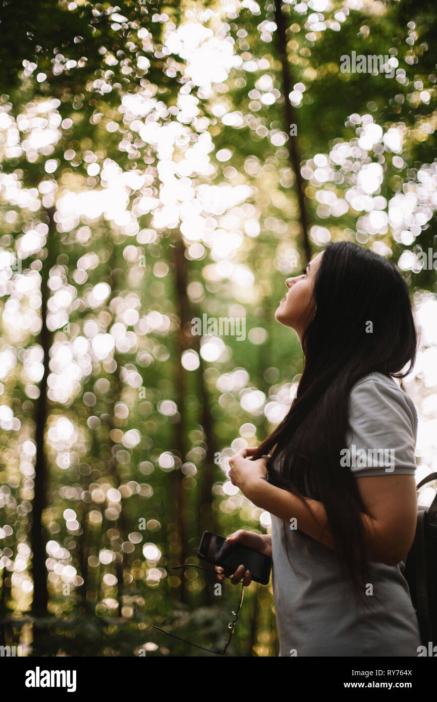 Low angle view of woman looking up while standing in park Stock Photo ...