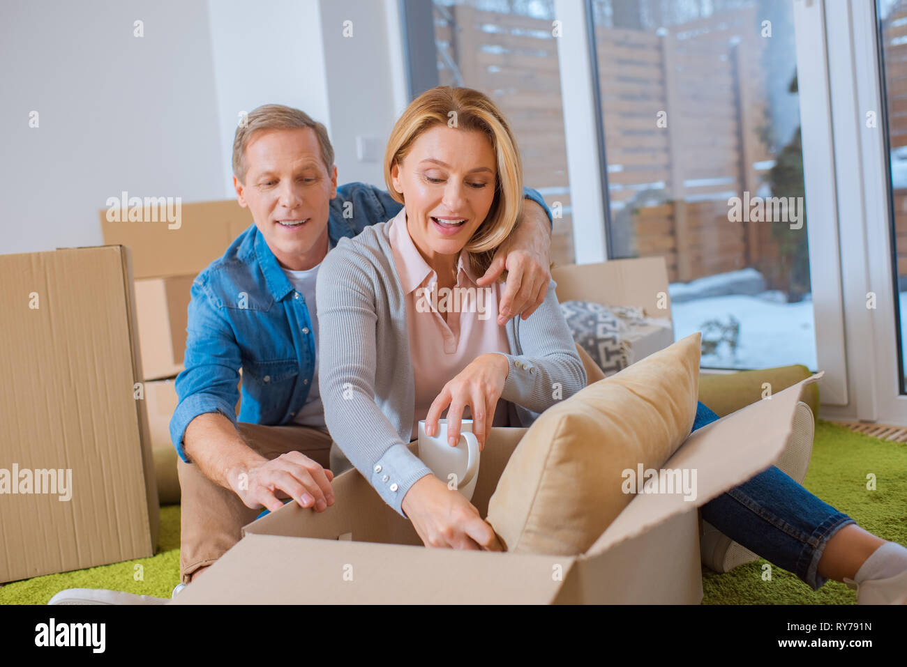 happy couple unpacking carton boxes at new home Stock Photo - Alamy