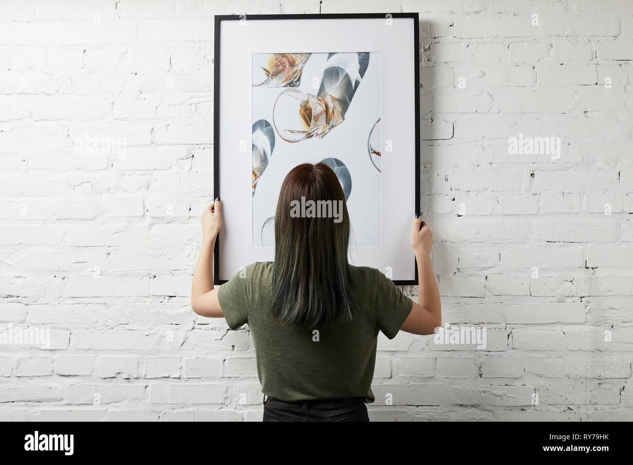 back view of woman holding drawing in black square frame Stock Photo ...