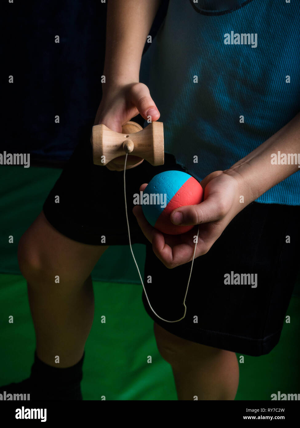 Classic Japanese game kendama, boy hands playing blue and pink color ...
