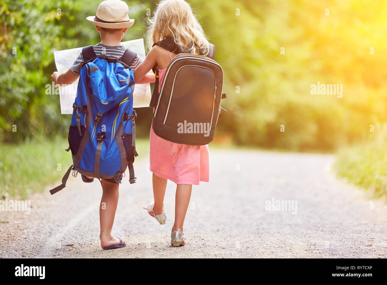 Two children go on adventure together in the summer with hiking map ...