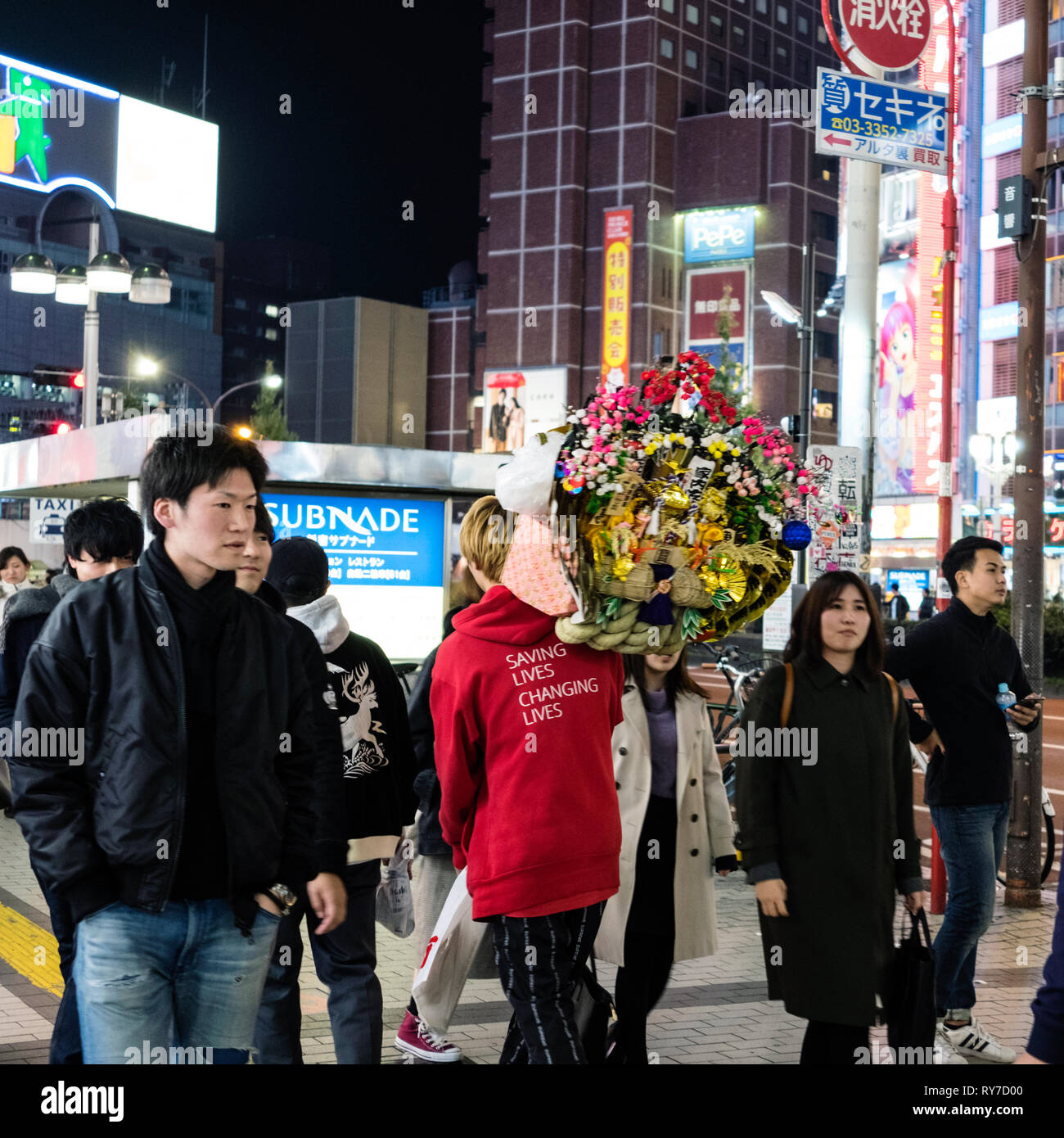 Man carrying a giant kumade charm after a shinto festival in Shinjuku ...