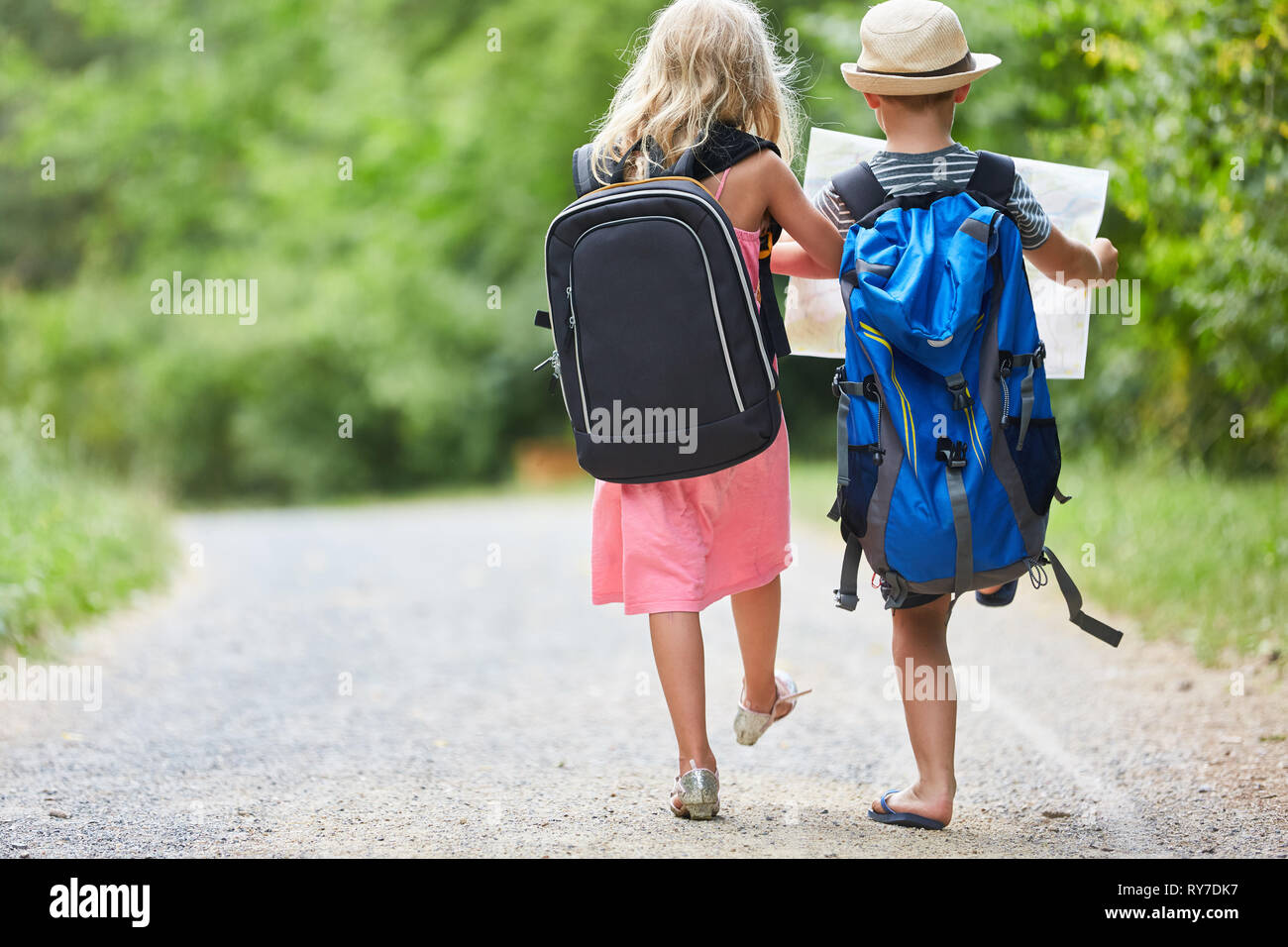 Two kids with backpack and map hiking together in nature Stock Photo ...