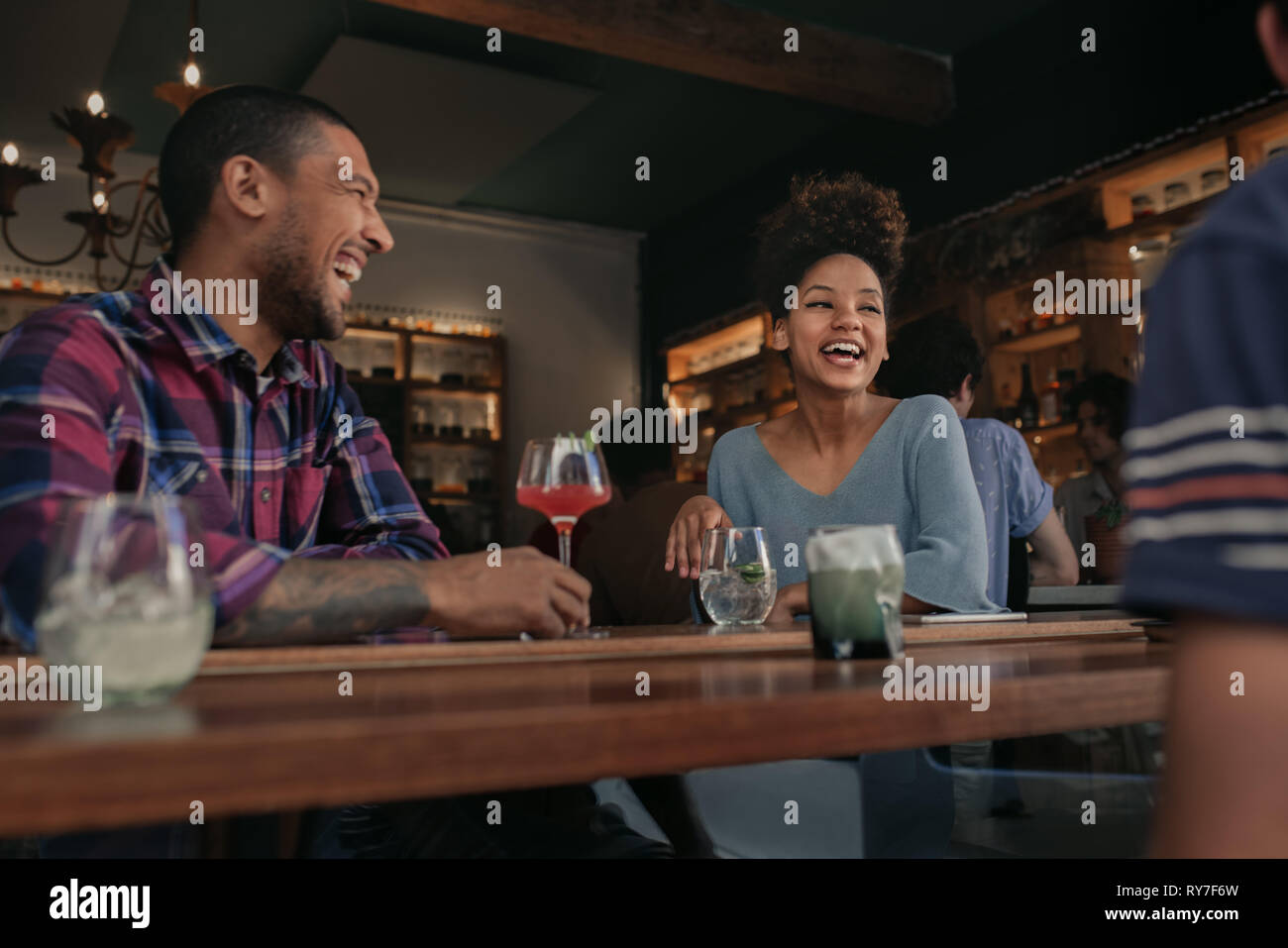 Friends having fun over drinks together in a bar Stock Photo - Alamy