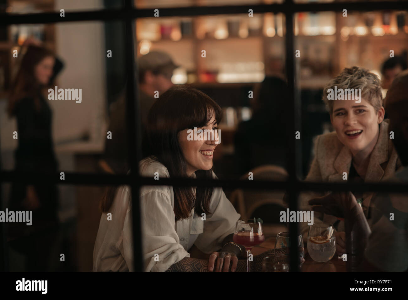 Friends talking over drinks at bar table in the evening Stock Photo - Alamy
