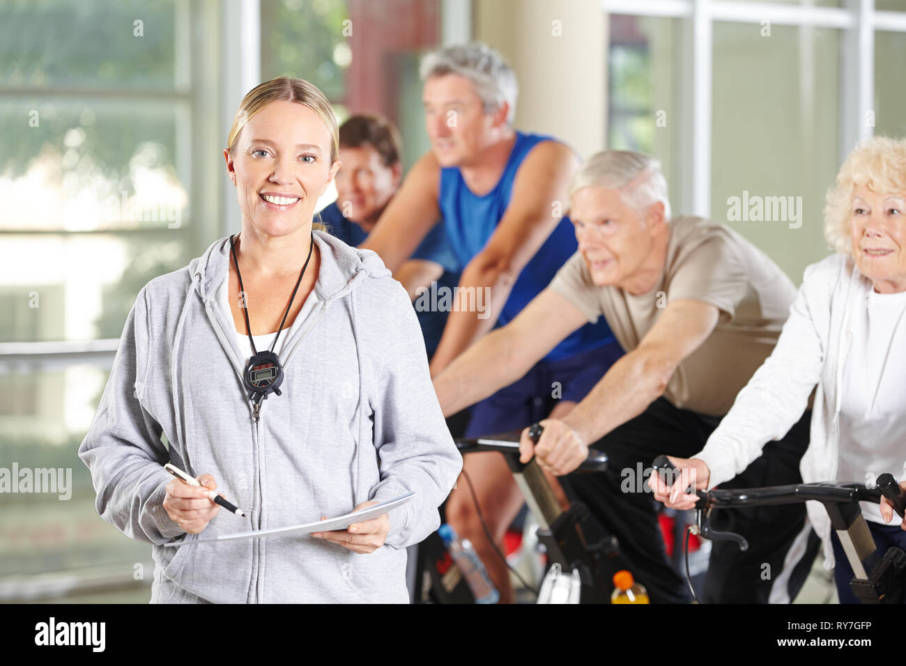 Woman with stopwatch and training plan as a trainer for seniors in the ...