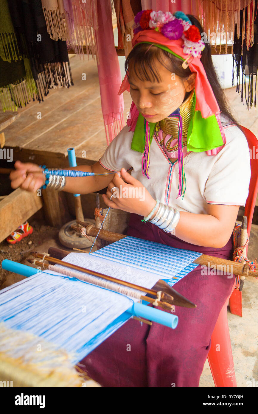 Kayan woman in traditional clothing weaving by hand fabric on a hand ...